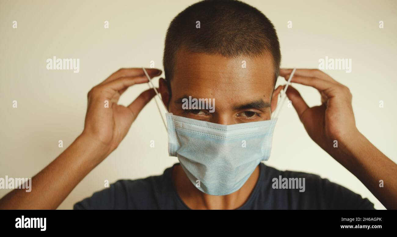 A young Indian guy putting a face mask on Stock Photo - Alamy