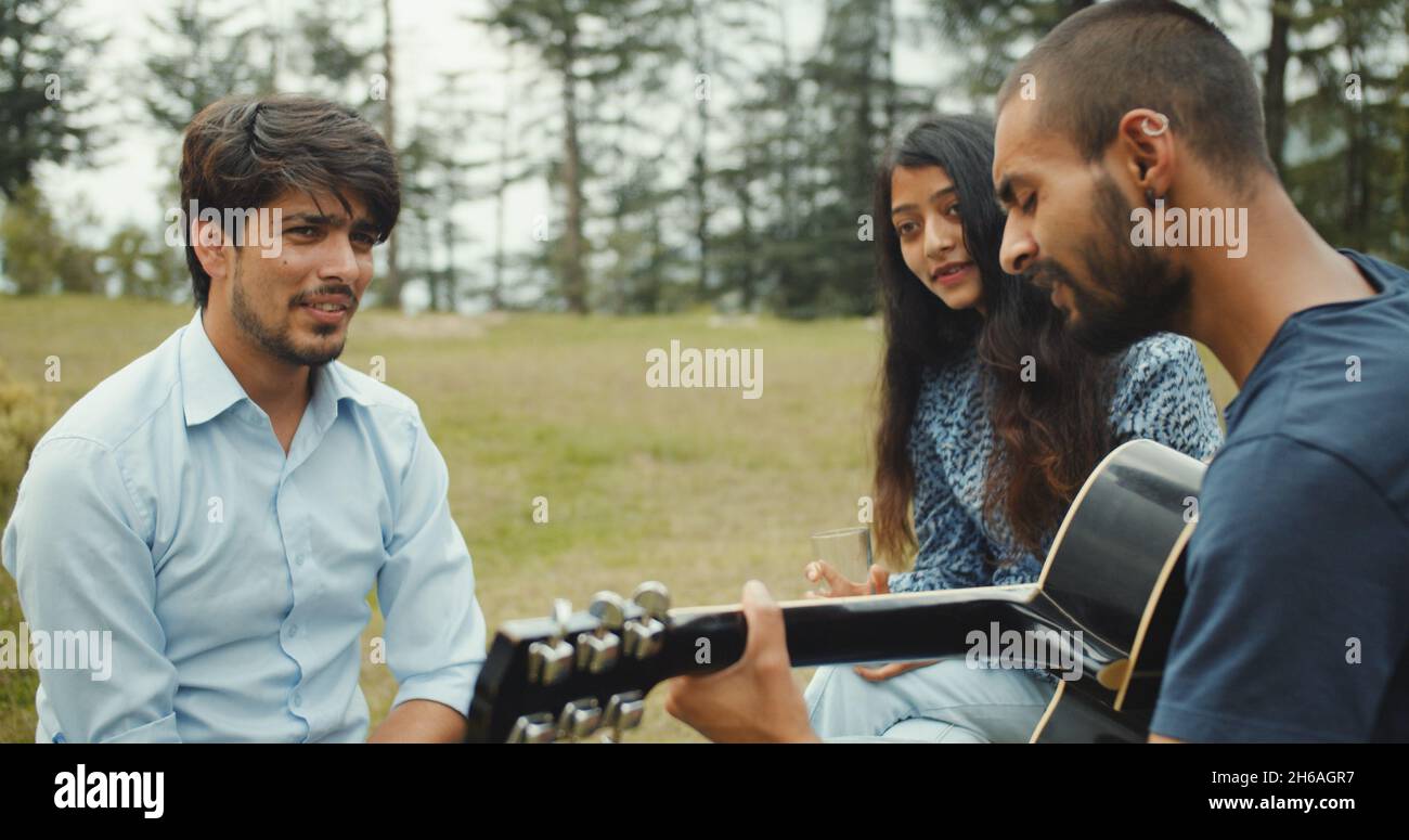 A group of Indian friends playing music in a park Stock Photo - Alamy