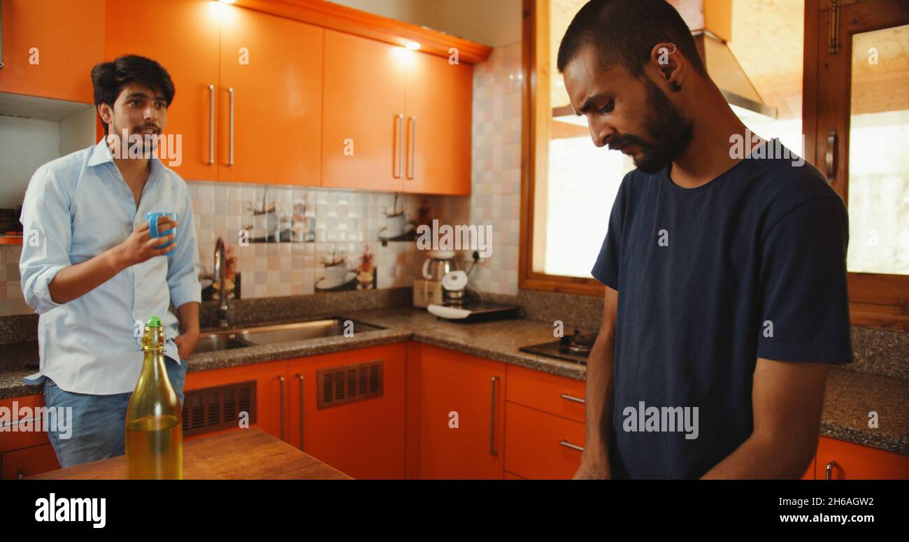 Two Indian friends talking while drinking coffee in the kitchen Stock ...