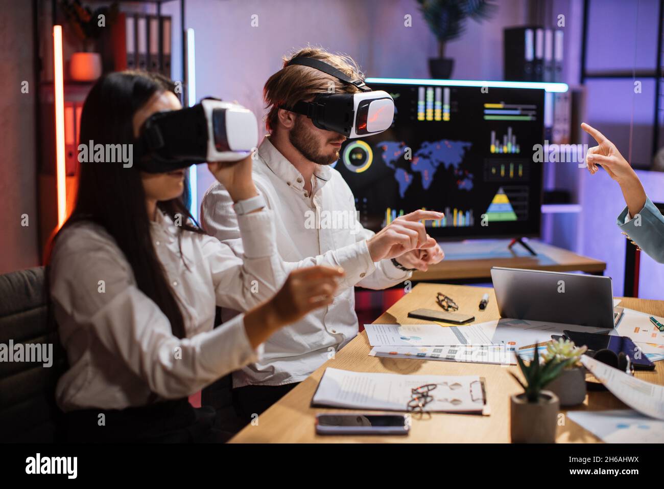 Group of multi ethnic business colleagues touching virtual screen while ...