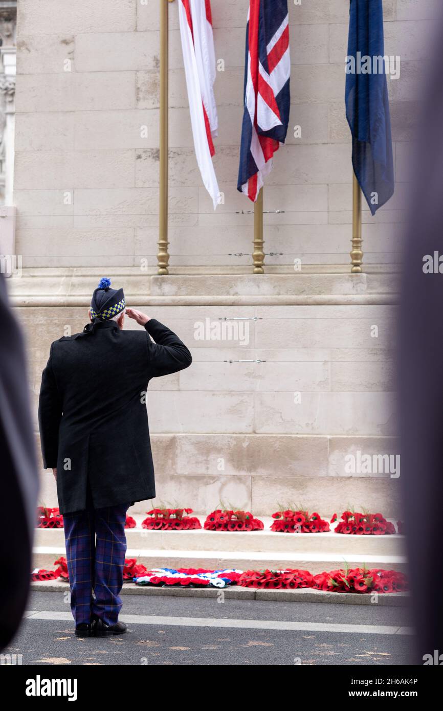 London, UK. 14th Nov, 2021. A dignitary salutes after laying his poppy ...