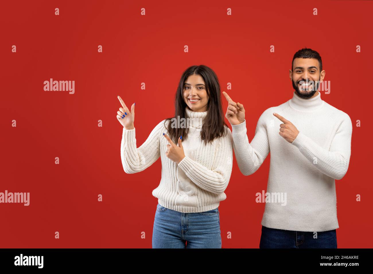 Unbelievable sale. Positive arab man and woman pointing fingers aside ...