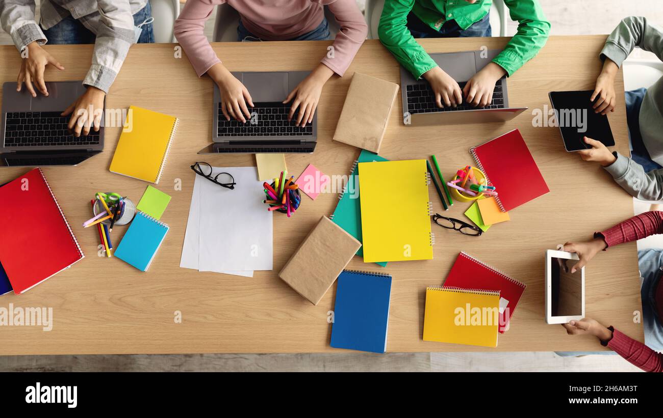 Top-View Of School Kids Using Laptop Computers Sitting At One Desk With ...