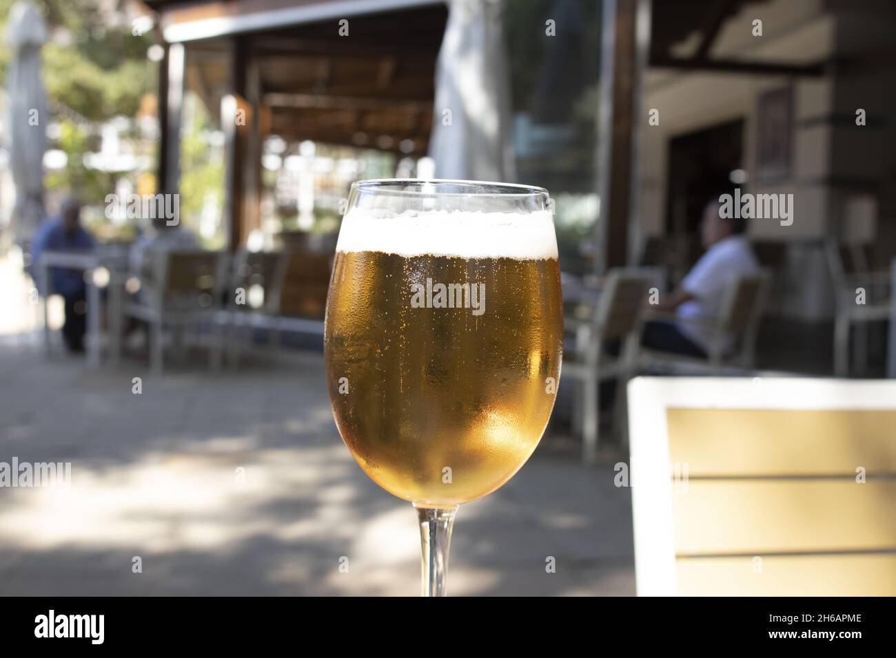 A closeup of a glass of cold drink on a blurry background at a cafe ...