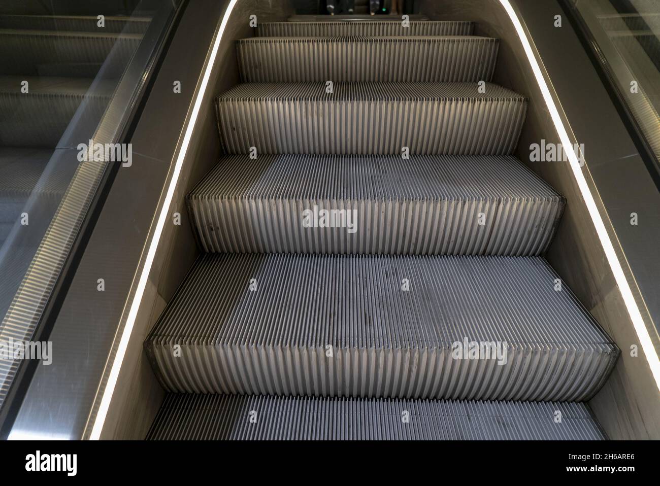 A close-up shot of empty escalator steps with a dirtproof grating Stock ...