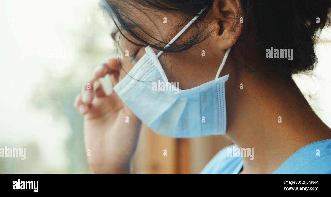 A tired young Indian female nurse crying with a face mask on Stock ...