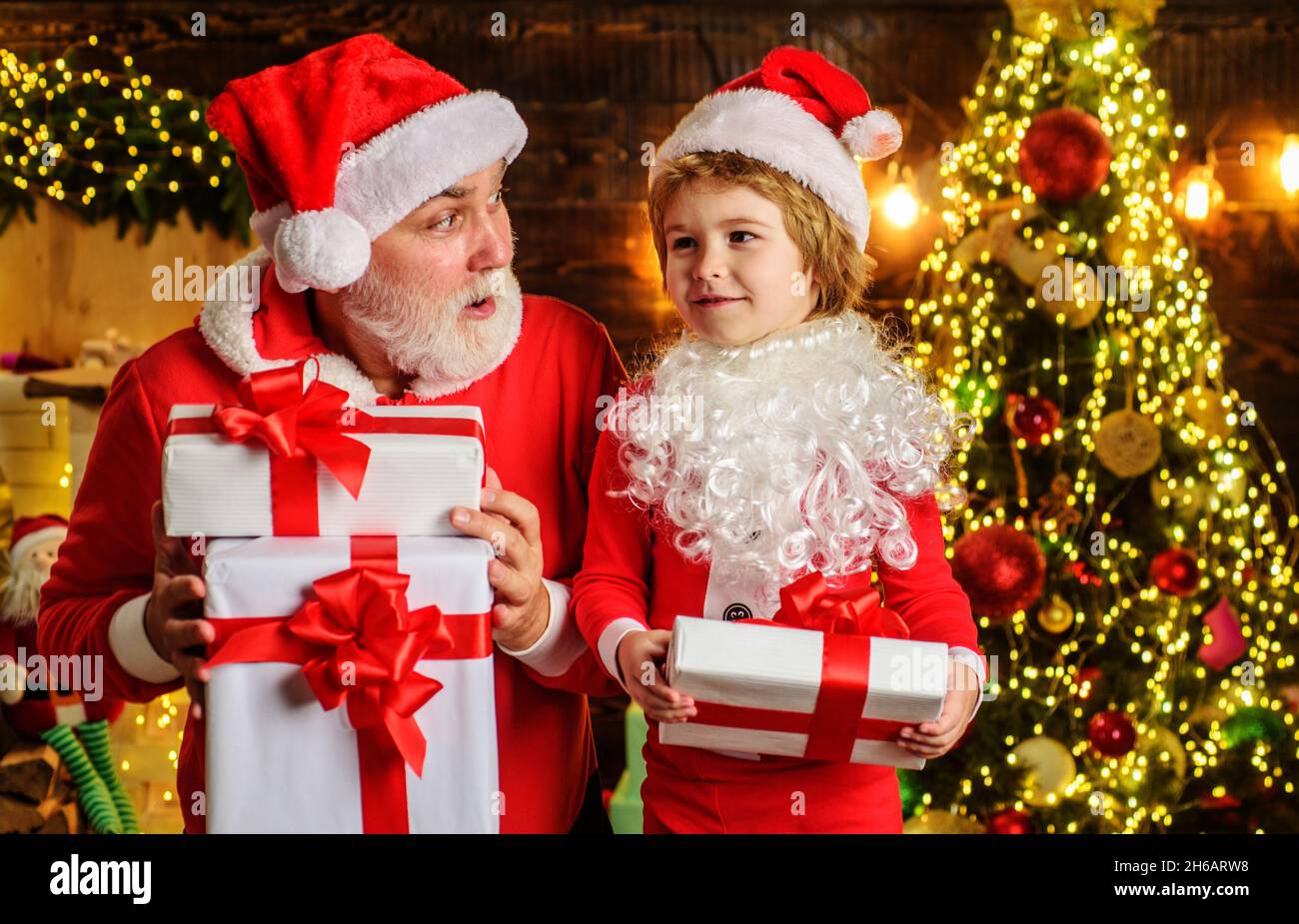 Santa Claus and child with Christmas present. Family holidays and ...