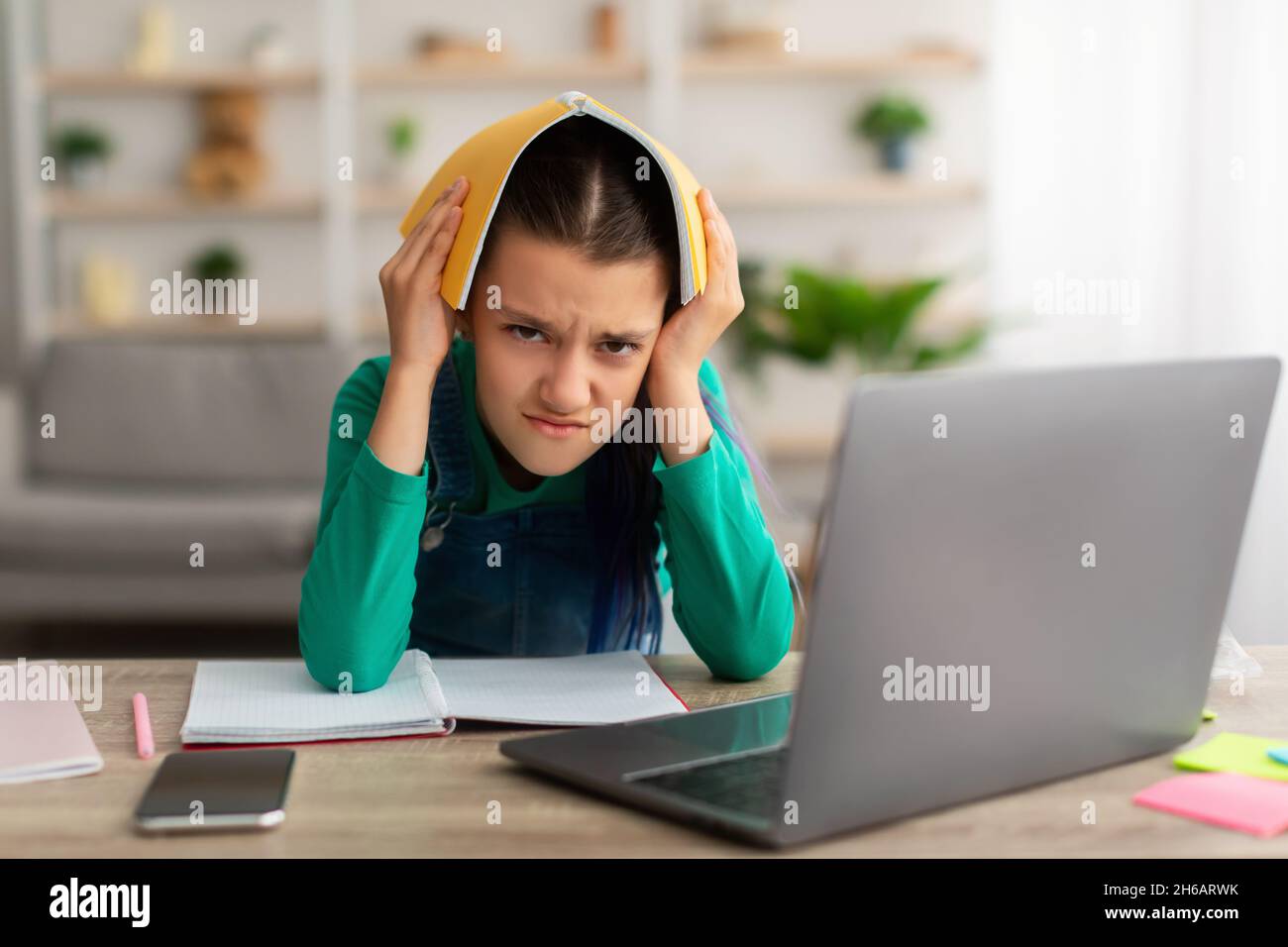 School Stress Concept. Angry tired student girl holding copybook on her ...