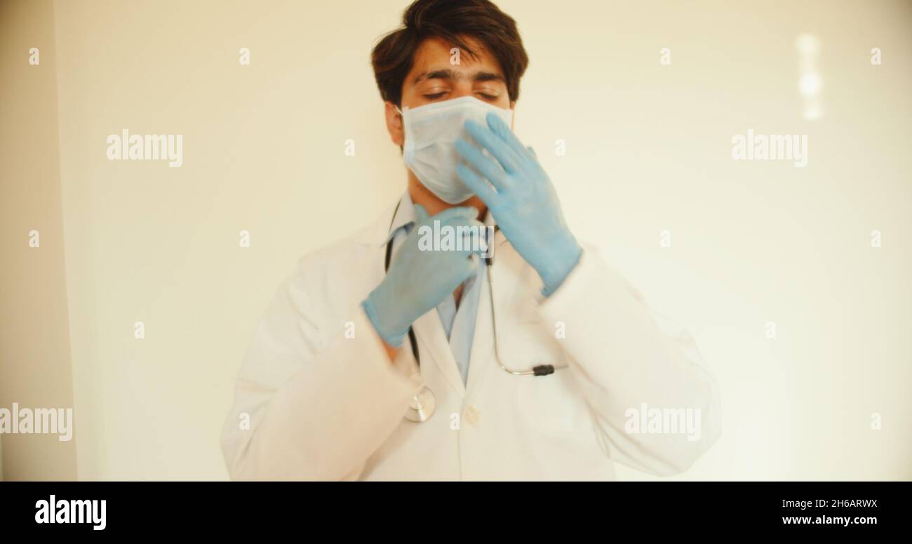 A young Indian doctor putting on his latex gloves Stock Photo - Alamy