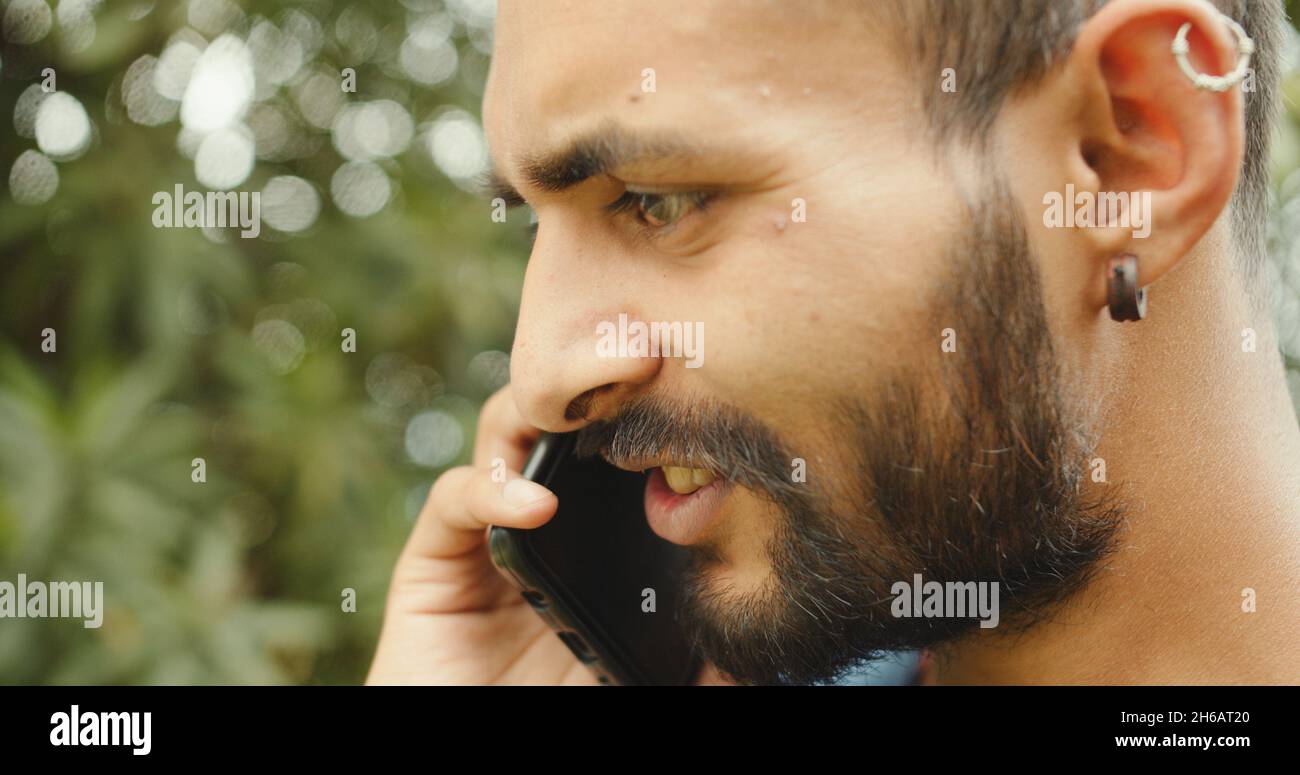 A young Indian guy talking on his phone Stock Photo - Alamy