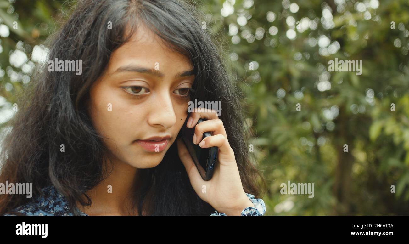 A young Indian female talking on her phone Stock Photo - Alamy