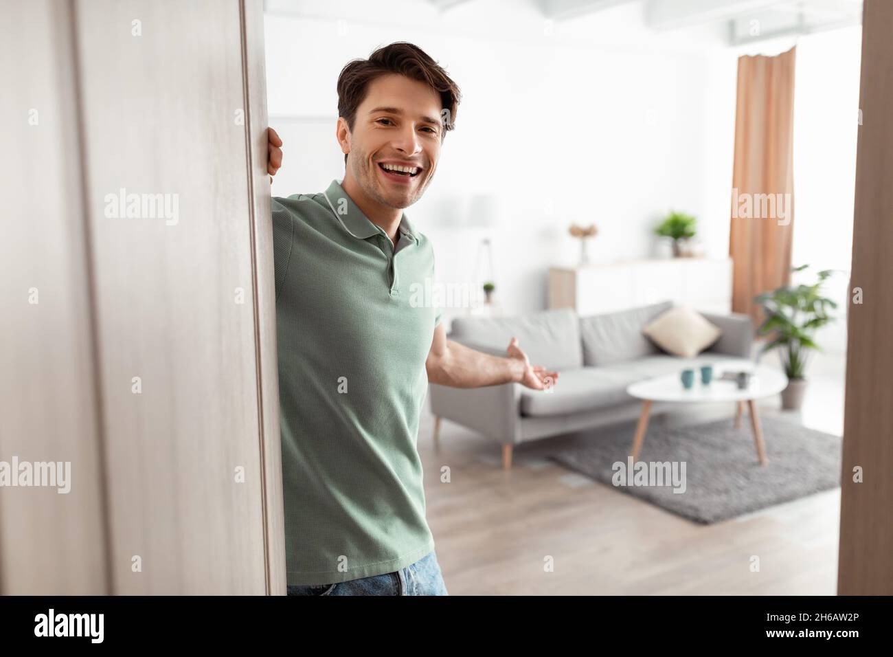 Welcome. Portrait of cheerful man inviting visitor to enter his home ...
