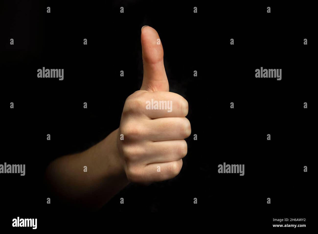 Success gesture, hand with thumb up sign on a black background ...