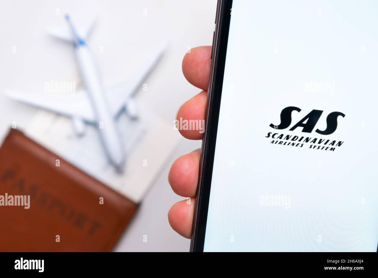 SAS airline. A mobile phone and SAS airline application in mans hand ...