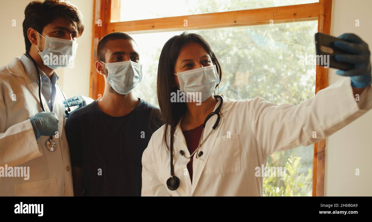 Two young Indian doctors taking a selfie with their patient Stock Photo ...