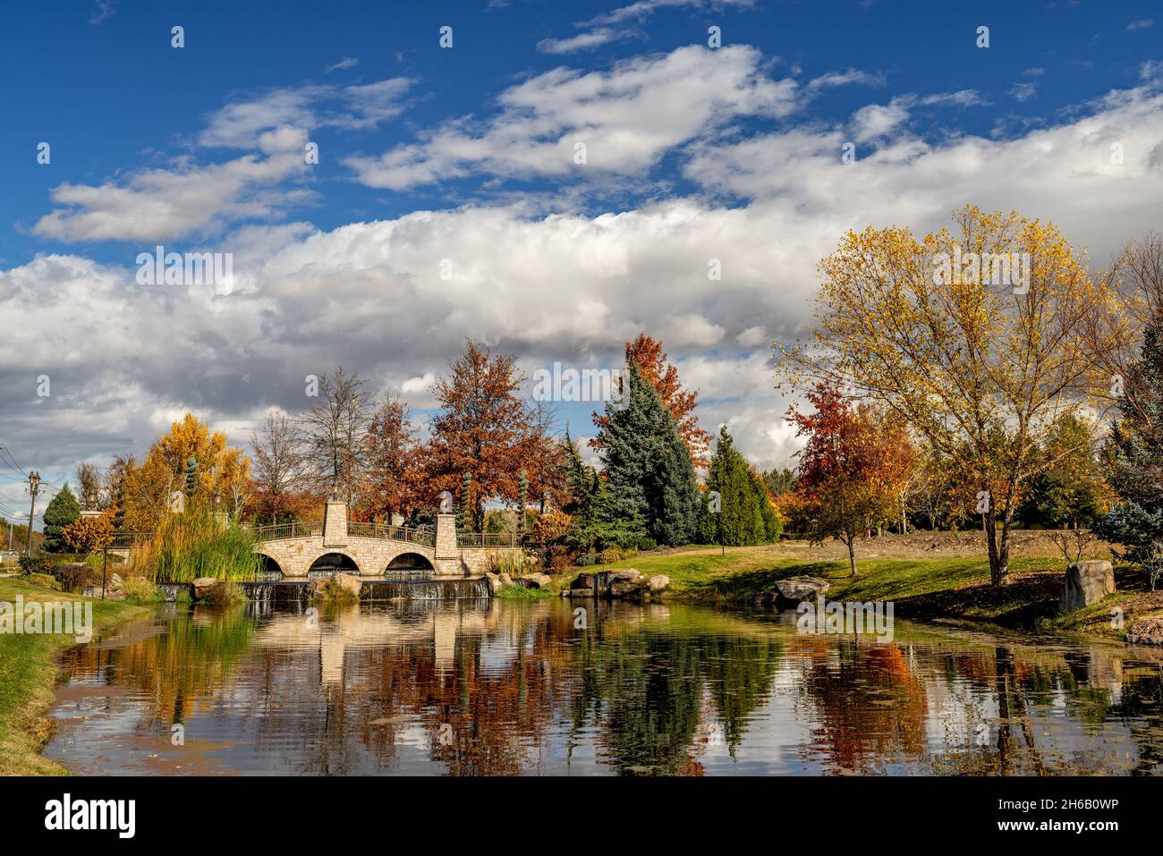 Autumn trees reflect in a pond with a fancy bridge Stock Photo - Alamy
