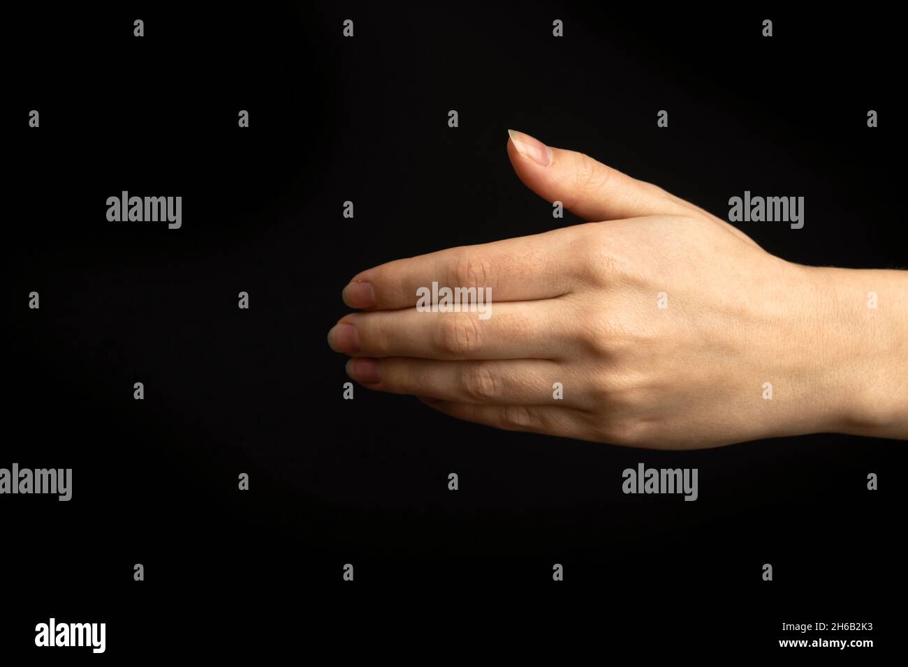 Young woman ready for handshake gesture on a black background. Business ...