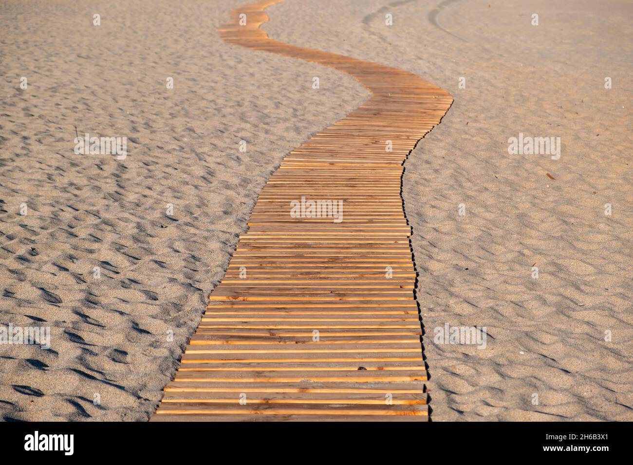 Beach boardwalk. Wooden planks winding empty walkway on sandy beach ...