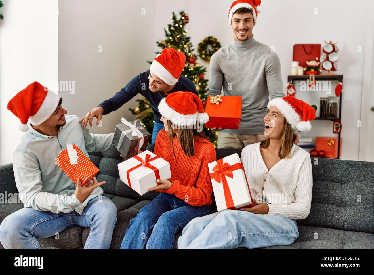 Group of young people giving christmas gift at home Stock Photo - Alamy