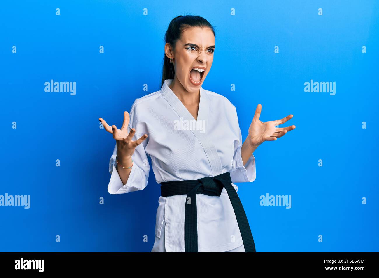 Beautiful brunette young woman wearing karate fighter uniform with ...