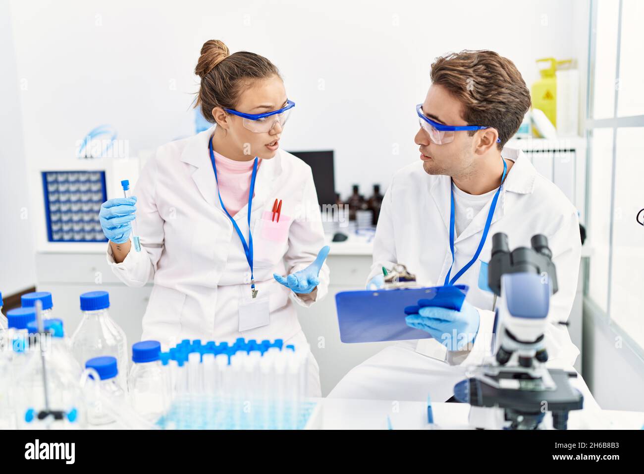 Man and woman wearing scientist uniform working at laboratory Stock ...