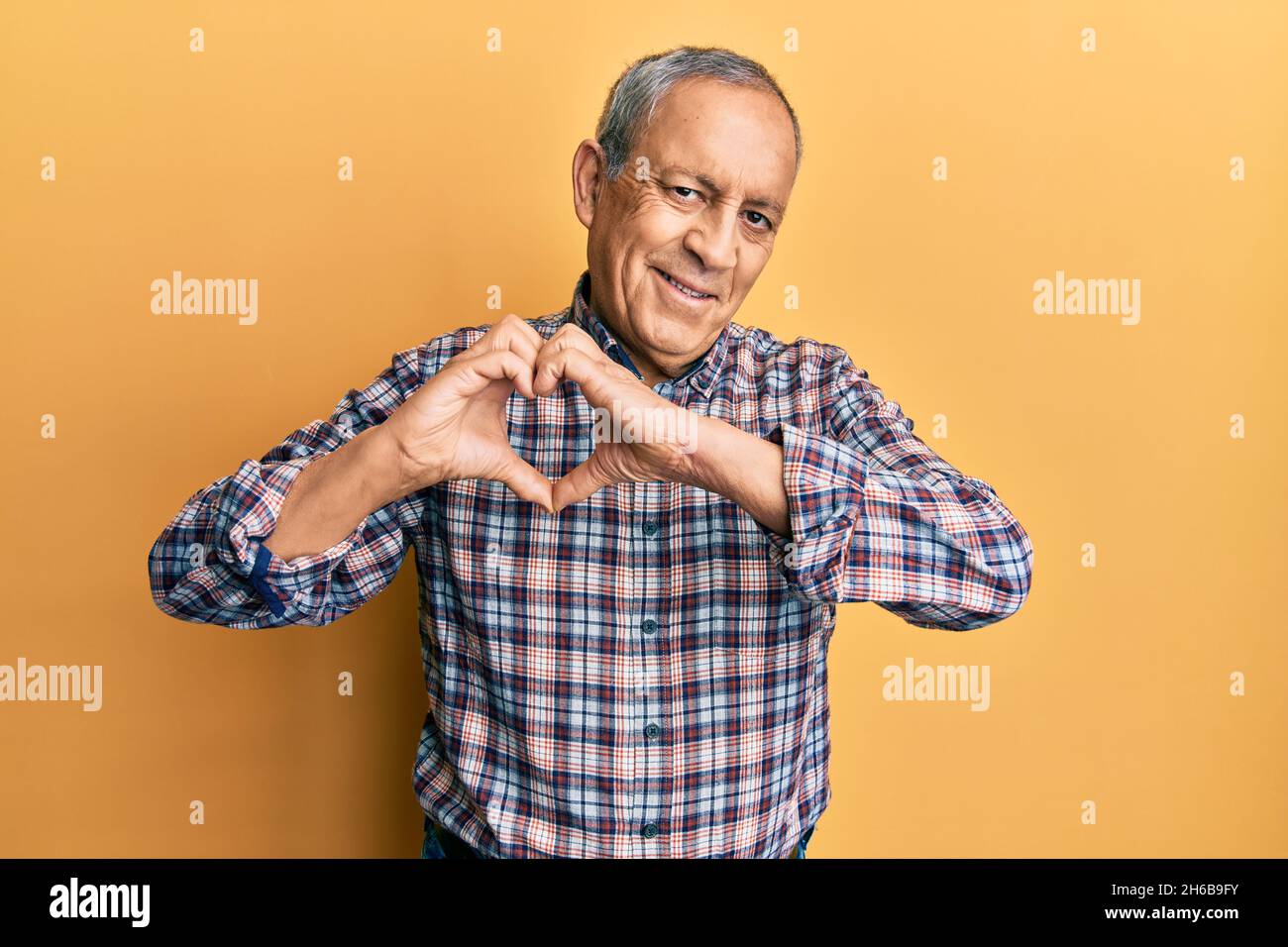 Handsome senior man with grey hair wearing casual shirt smiling in love ...