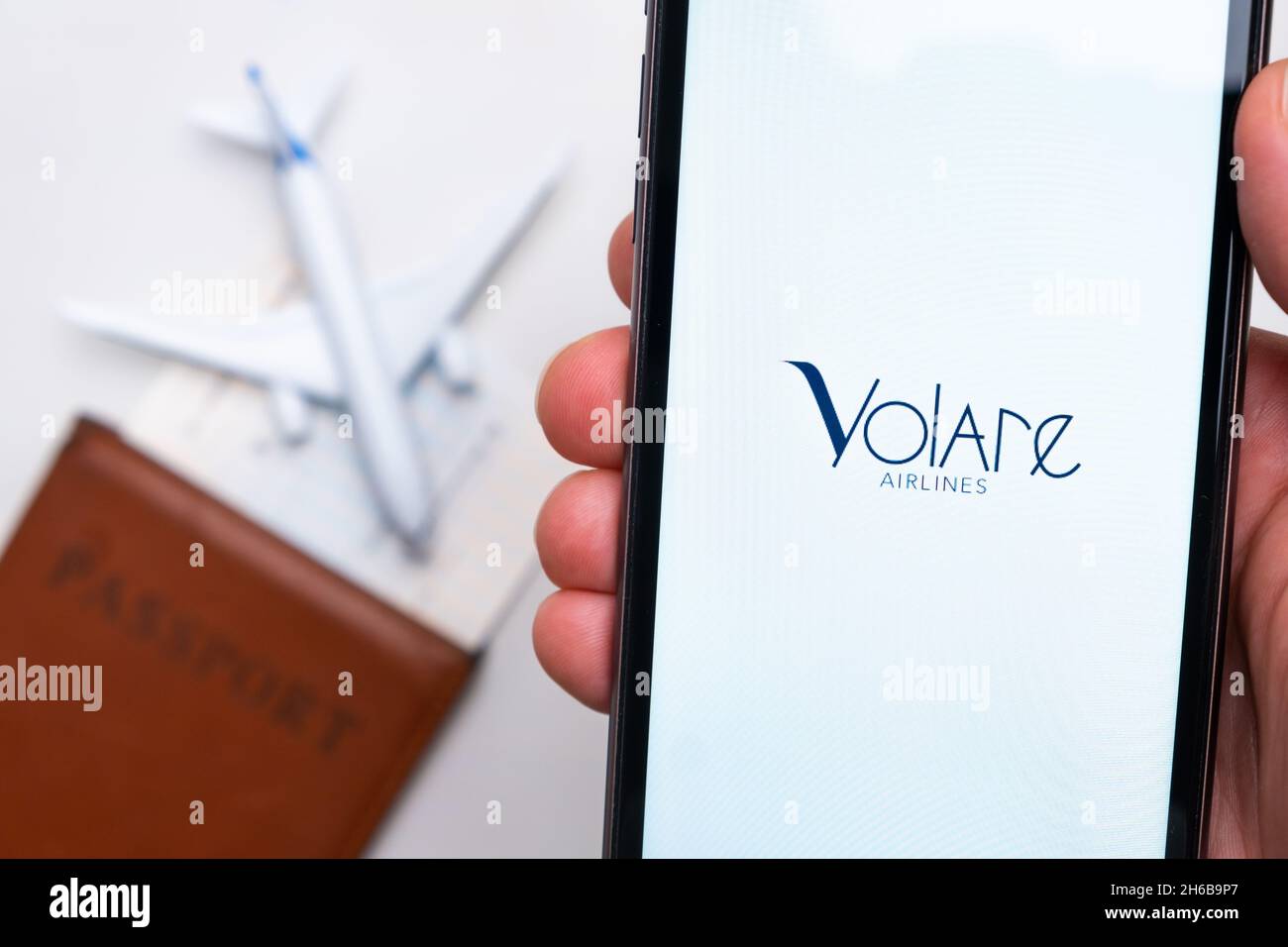 Volare Airline application on the smartphone screen mans hand. A white ...