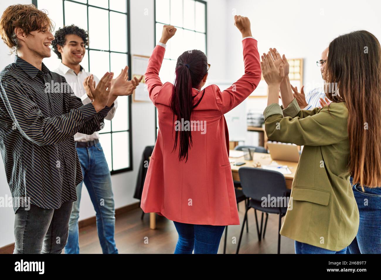 Group of business workers smiling and clapping to partner standing at ...
