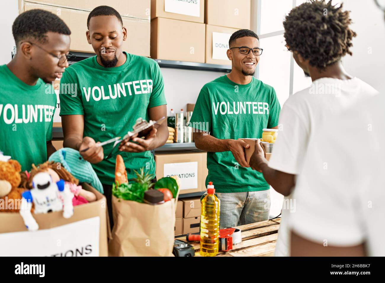 Group of young african american volunteers helping people at charity ...
