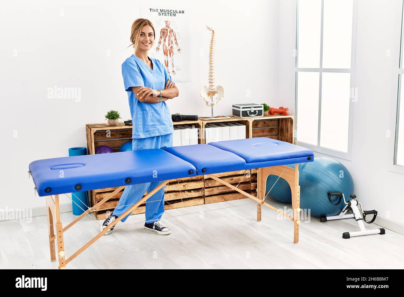 Young caucasian physio therapist smiling happy standing with arms ...
