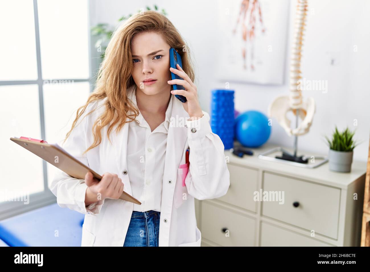 Young caucasian woman working at rehabilitation clinic speaking on the ...