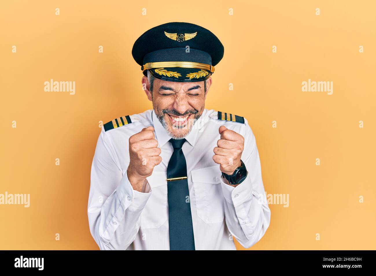 Handsome middle age man with grey hair wearing airplane pilot uniform ...