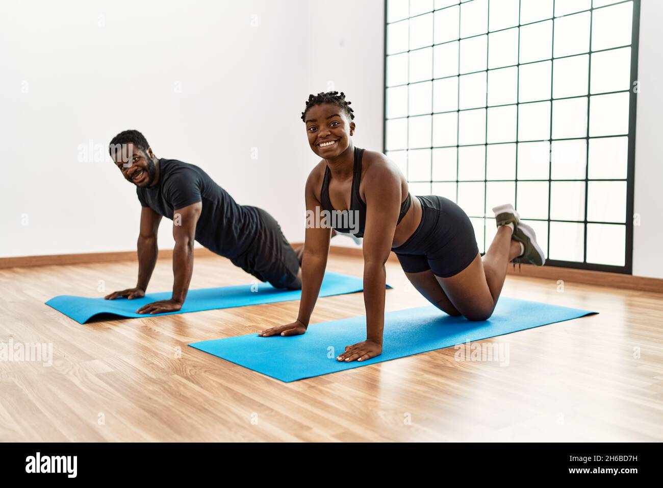 Young african american sporty couple smiling happy doing core abs ...