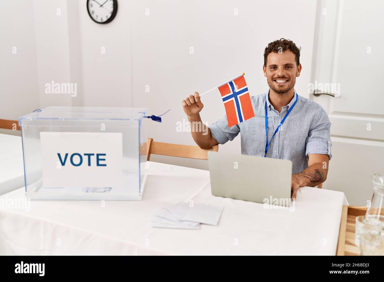 Young hispanic man smiling confident holding norway flag working at ...