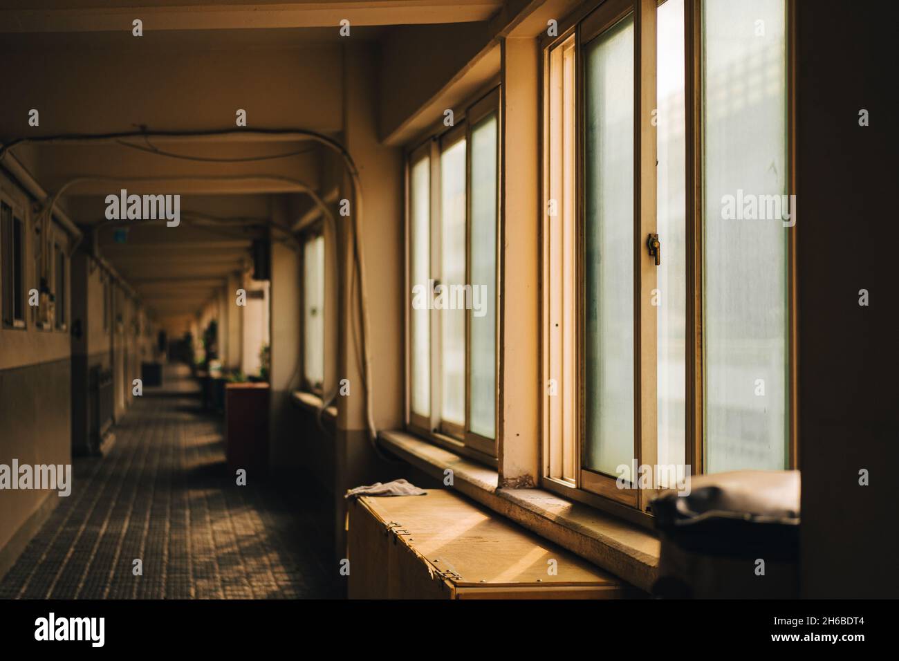 The warm sunshine is coming through the windows with an empty hallway ...