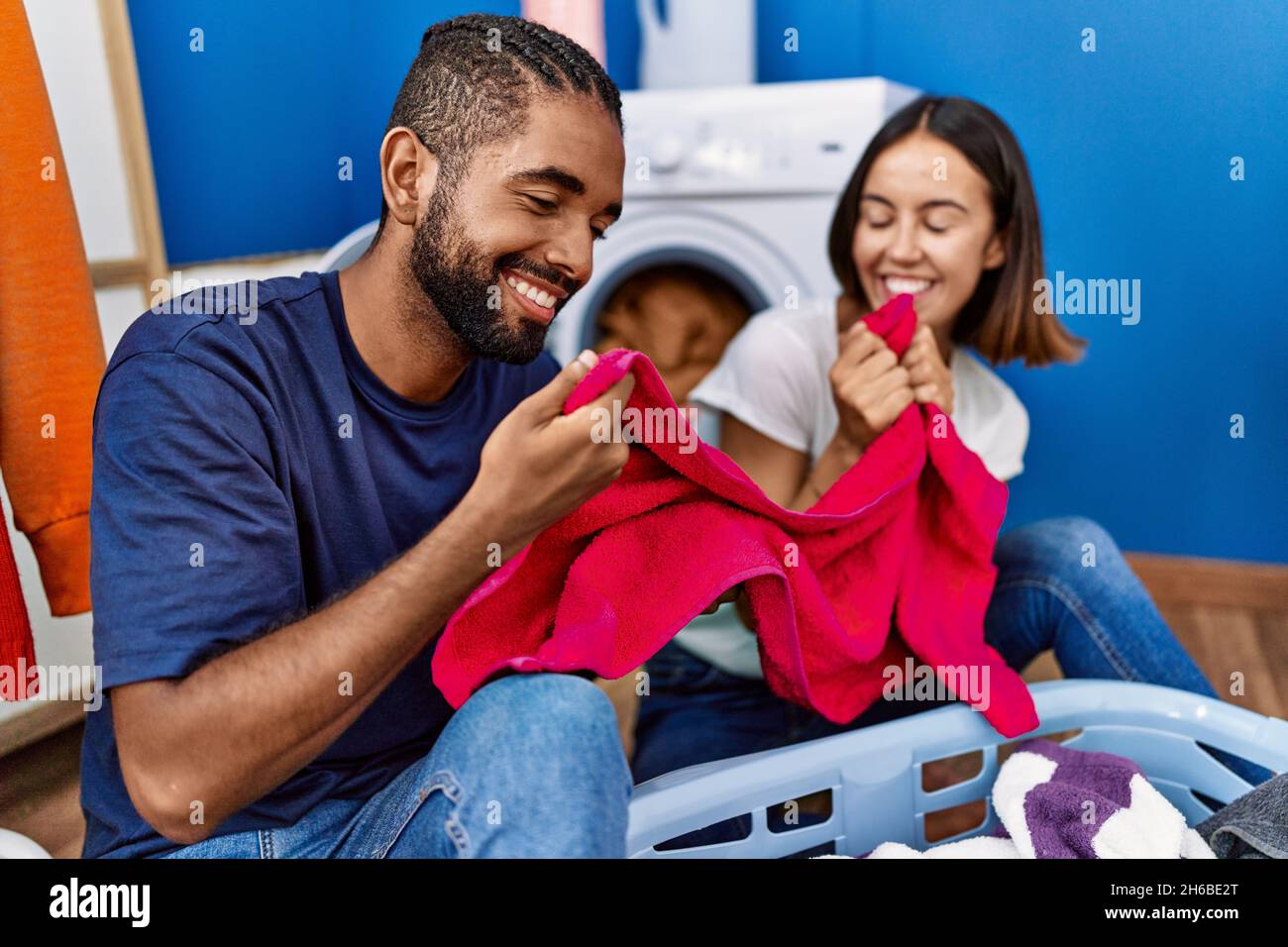 Man and woman couple smelling towel washing clothes at laundry Stock Photo - Alamy