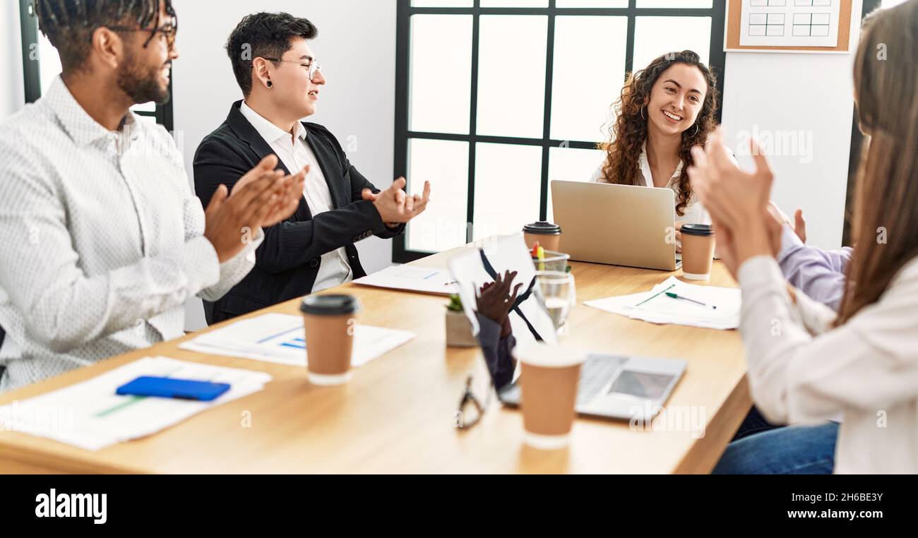 Group of business workers smiling and clapping to partner at the office ...