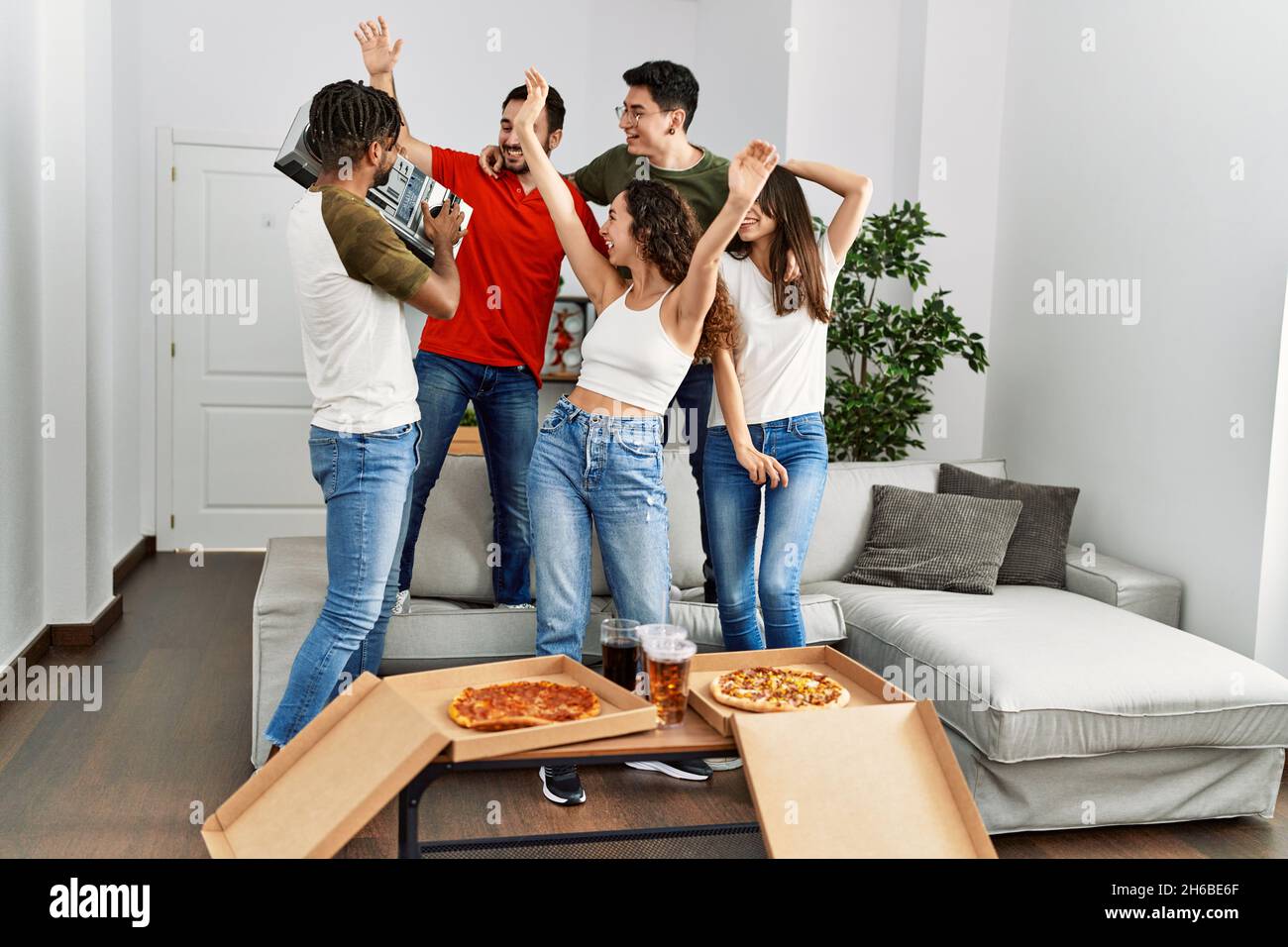 Group of young friends having party eating italian pizza and and ...