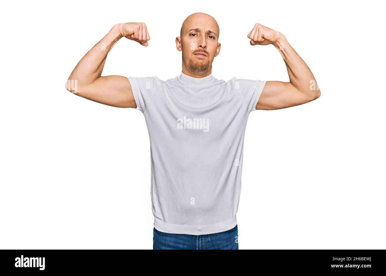 Bald man with beard wearing casual white t shirt showing arms muscles ...