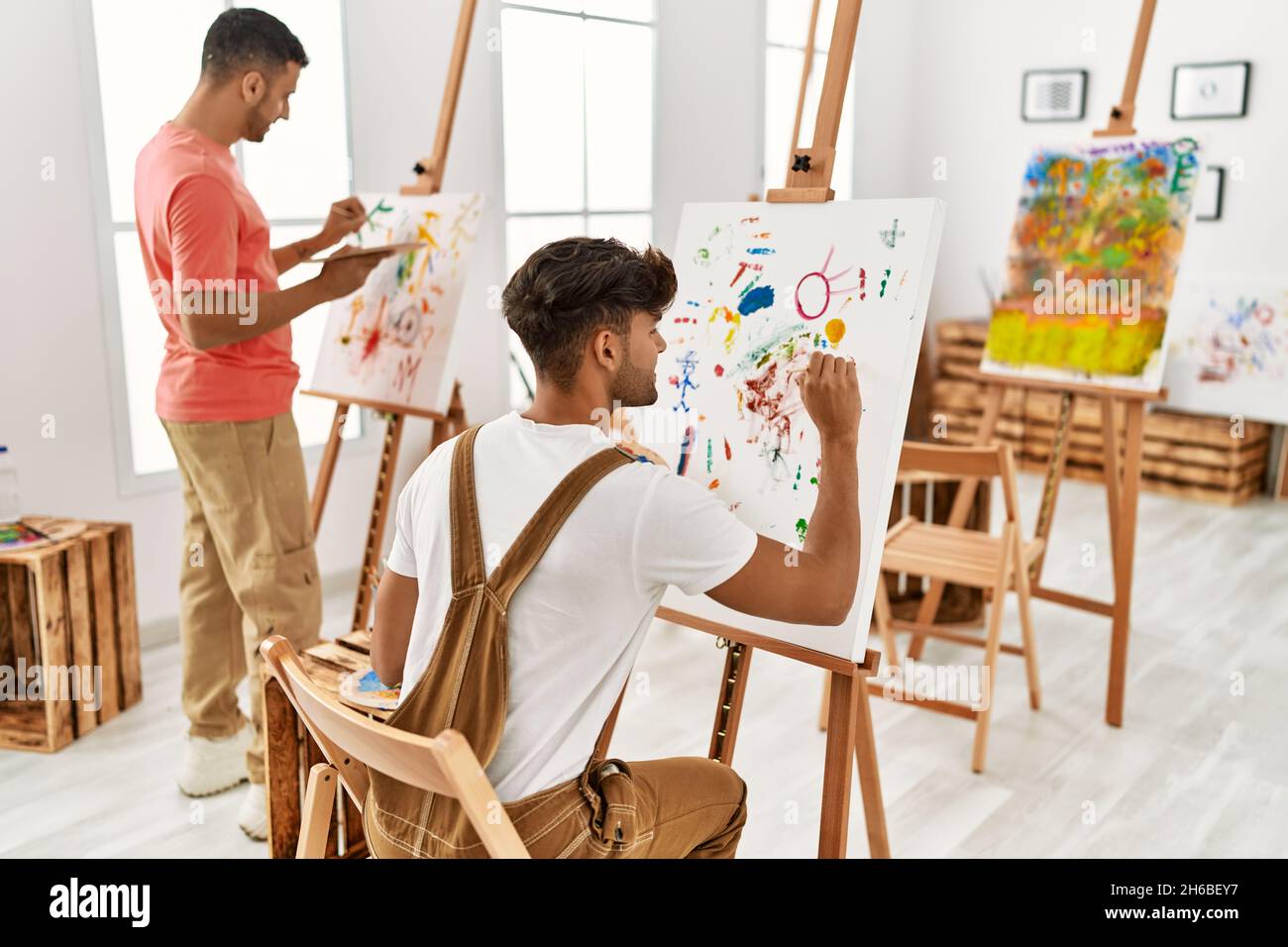 Two hispanic men couple smiling confident drawing at art studio Stock ...