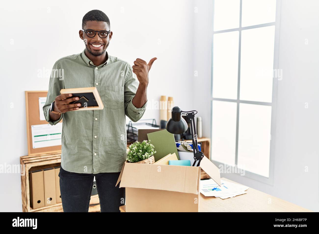 Young african american businessman unboxing box at the office pointing ...