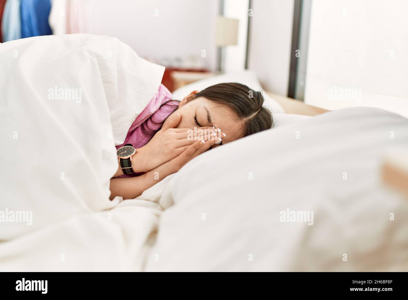 Young Chinese Girl Sleeping On The Bed Covering Face With Hands At