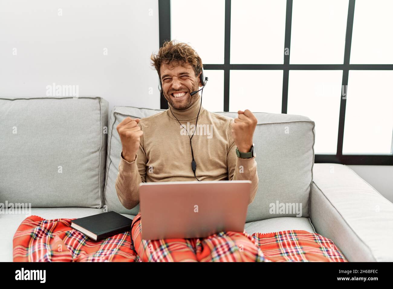 Young handsome man with beard wearing operator headset working from ...