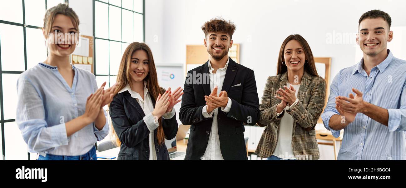 Group of young business workers smiling happy and clapping. Standing ...