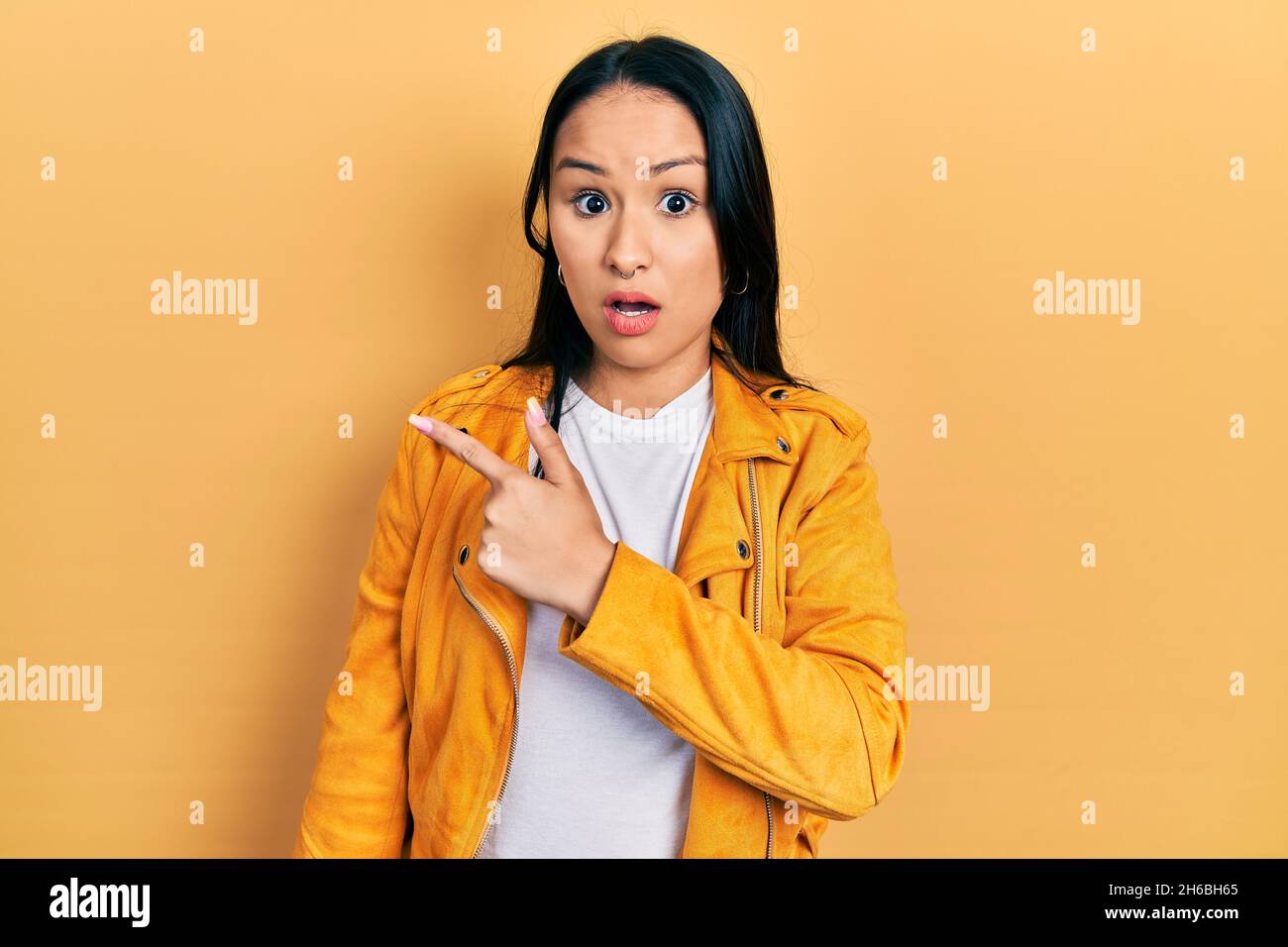 Beautiful hispanic woman with nose piercing wearing yellow leather ...