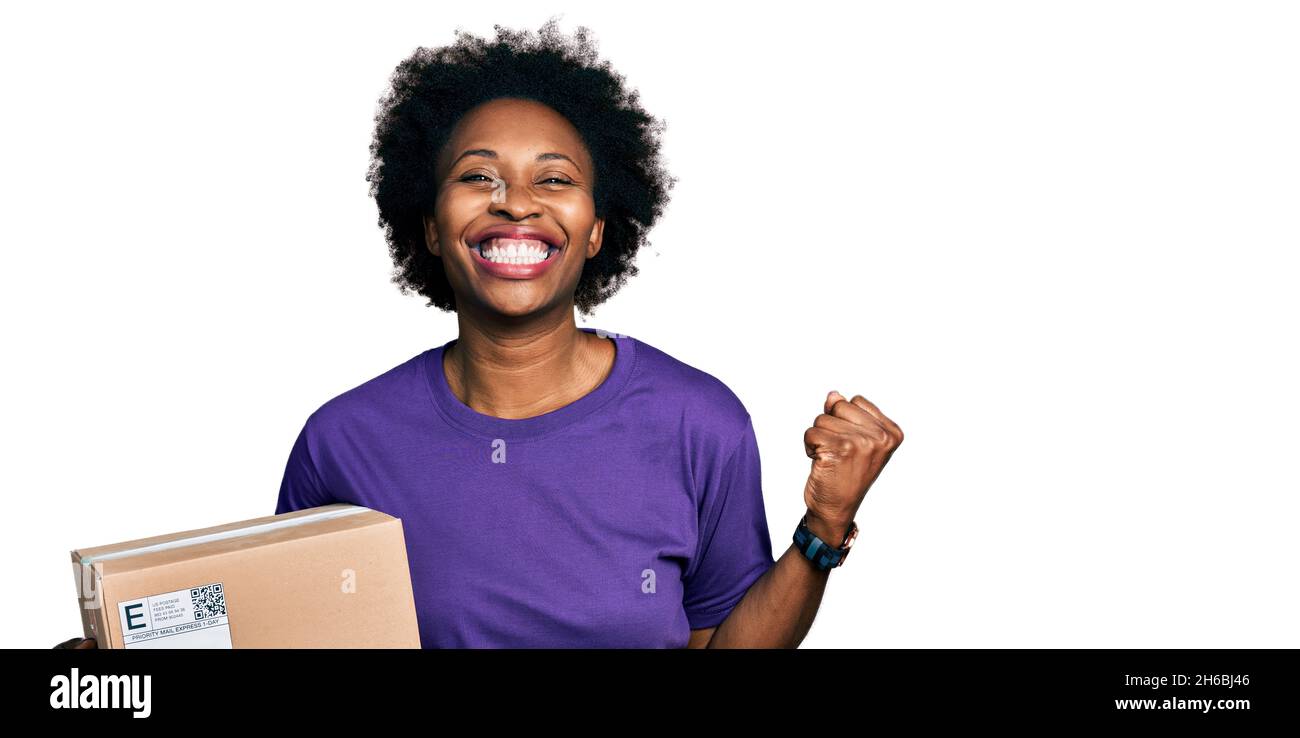 African american woman with afro hair holding delivery package ...