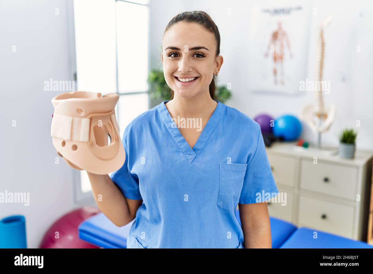 Young physiotherapist woman holding cervical neck collar at medical ...