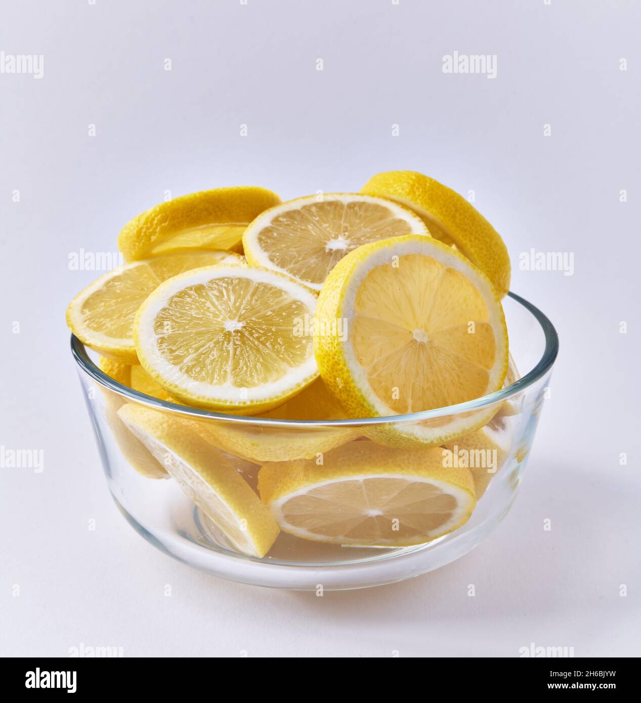 Bowl of slices of lemon isolated on a white background Stock Photo - Alamy