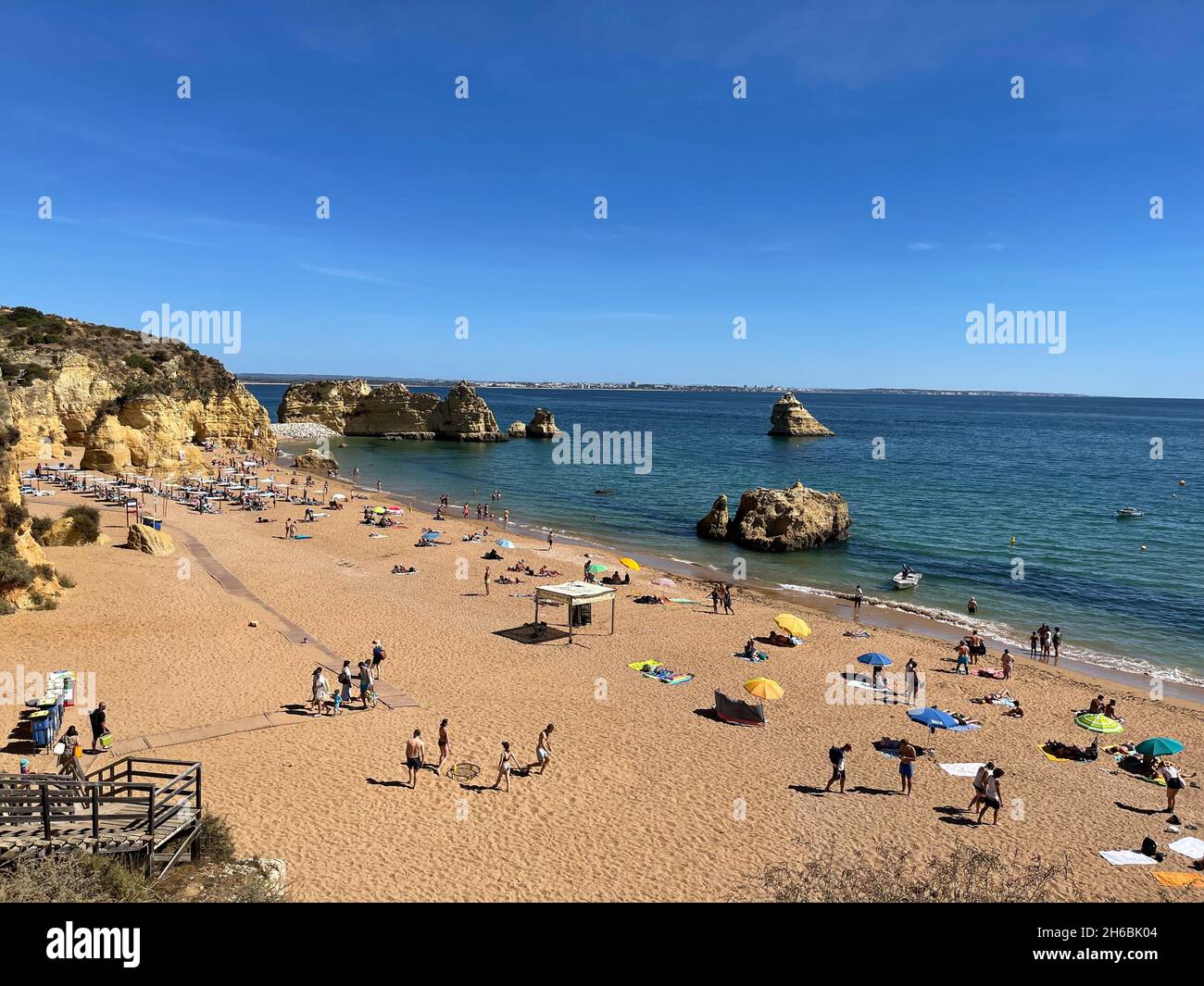 Praia Dona Ana beach with turquoise sea water and cliffs, flying ...