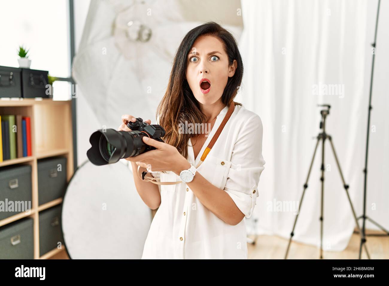 Beautiful caucasian woman working as photographer at photography studio ...